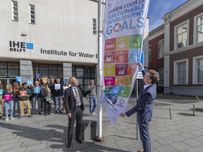 Wethouder en rector hijsen SDGvlag - Delft4GlobalGoals